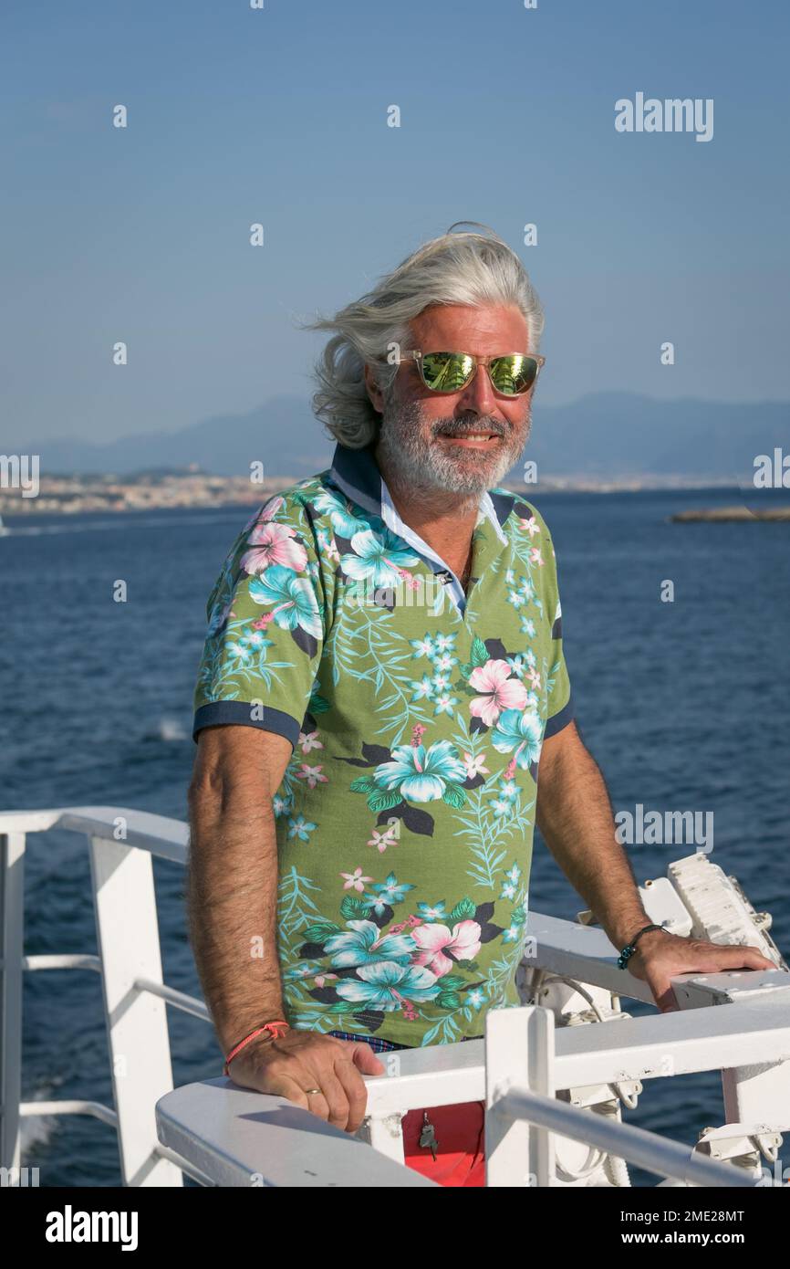 Middle-aged handsome man with long grey hair, wearing a floral shirt ...