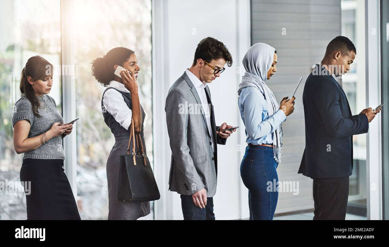 Standing in line at work. a group of businesspeople standing in a row ...