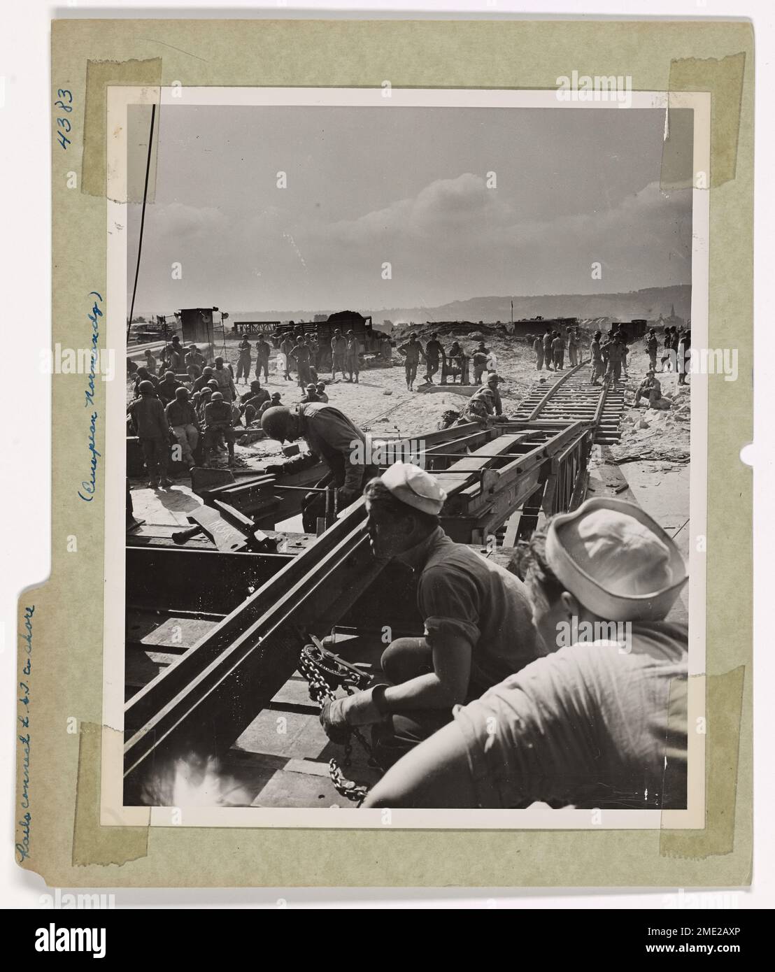 Coast Guardsmen and soldiers work together to establish a rail bridge ...