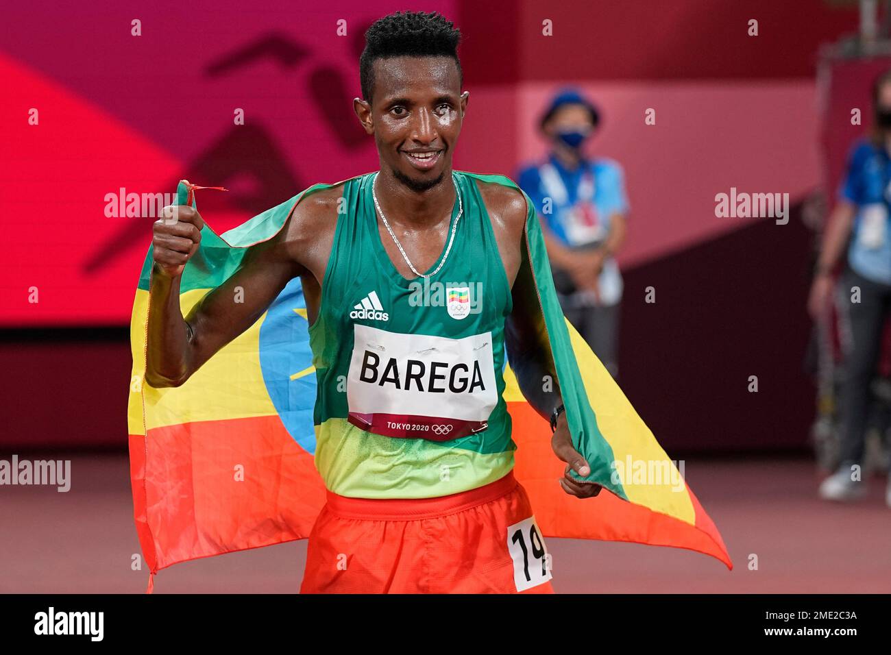 Selemon Barega, of Ethiopia, poses with his national flag after winning ...