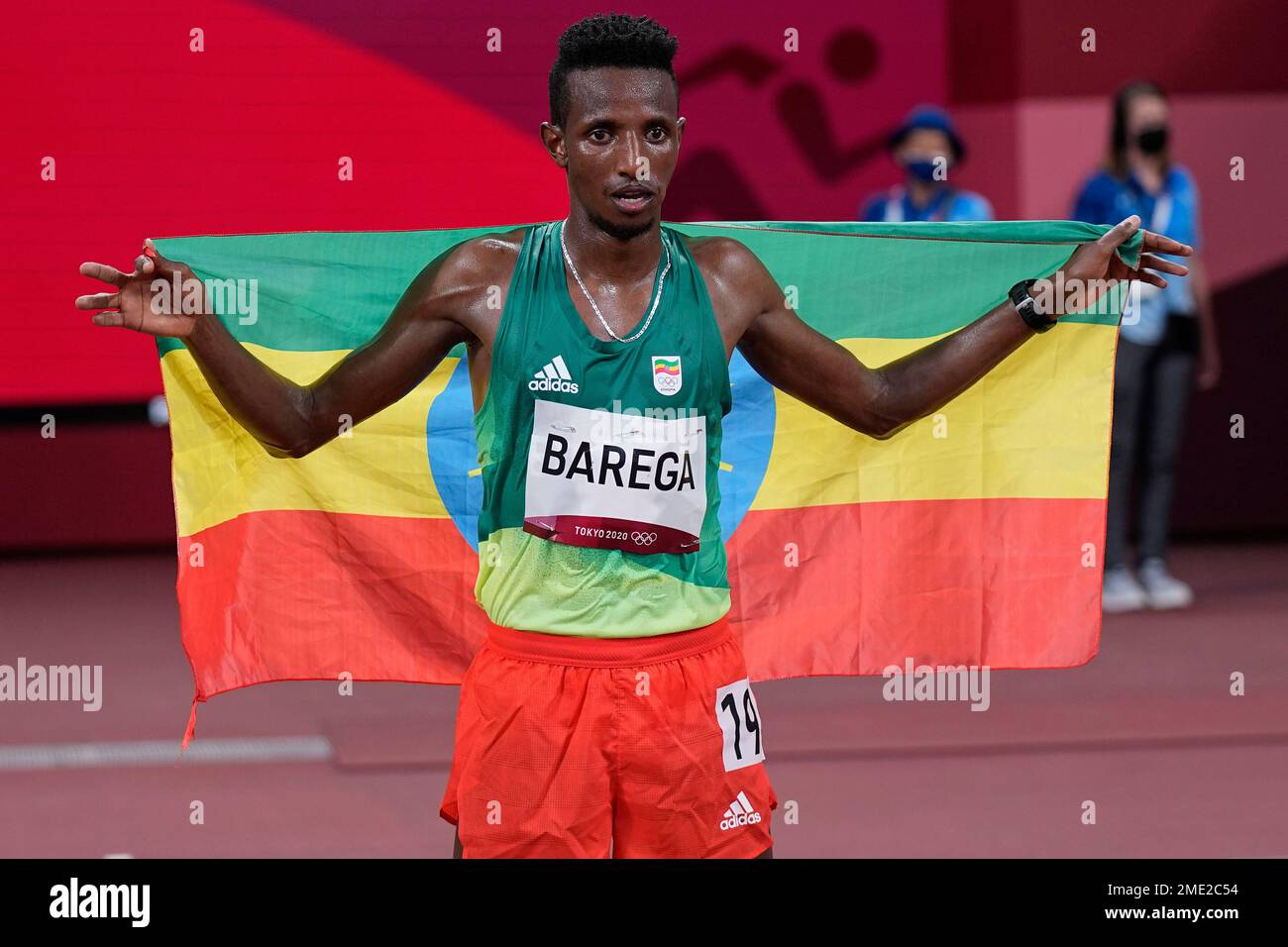 Selemon Barega, of Ethiopia, poses with his national flag after winning ...