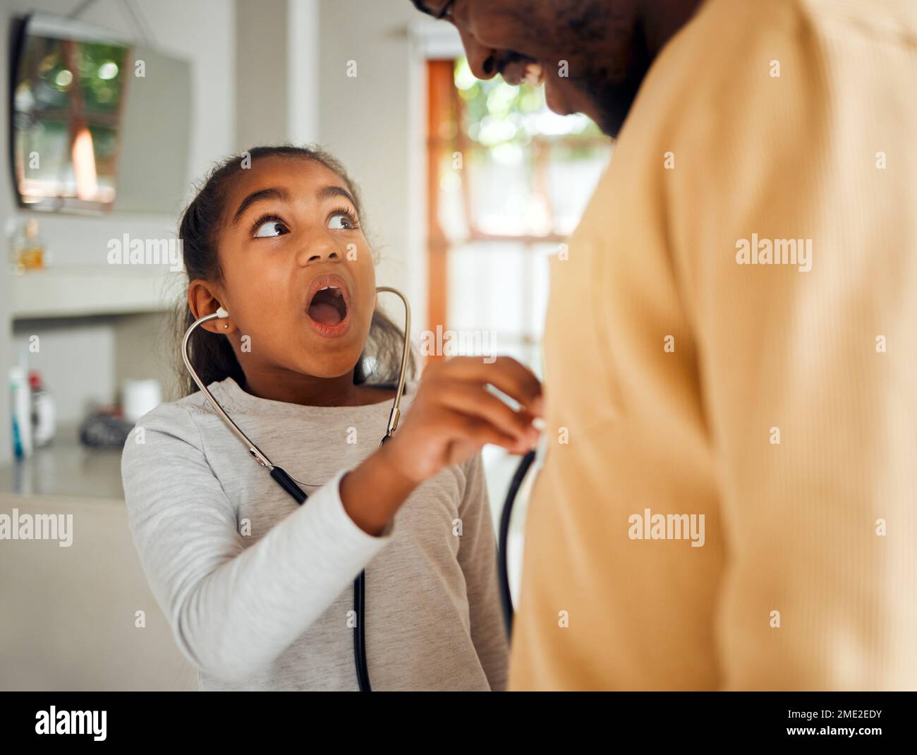 Surprise, stethoscope and girl play with father, caring and bonding in ...