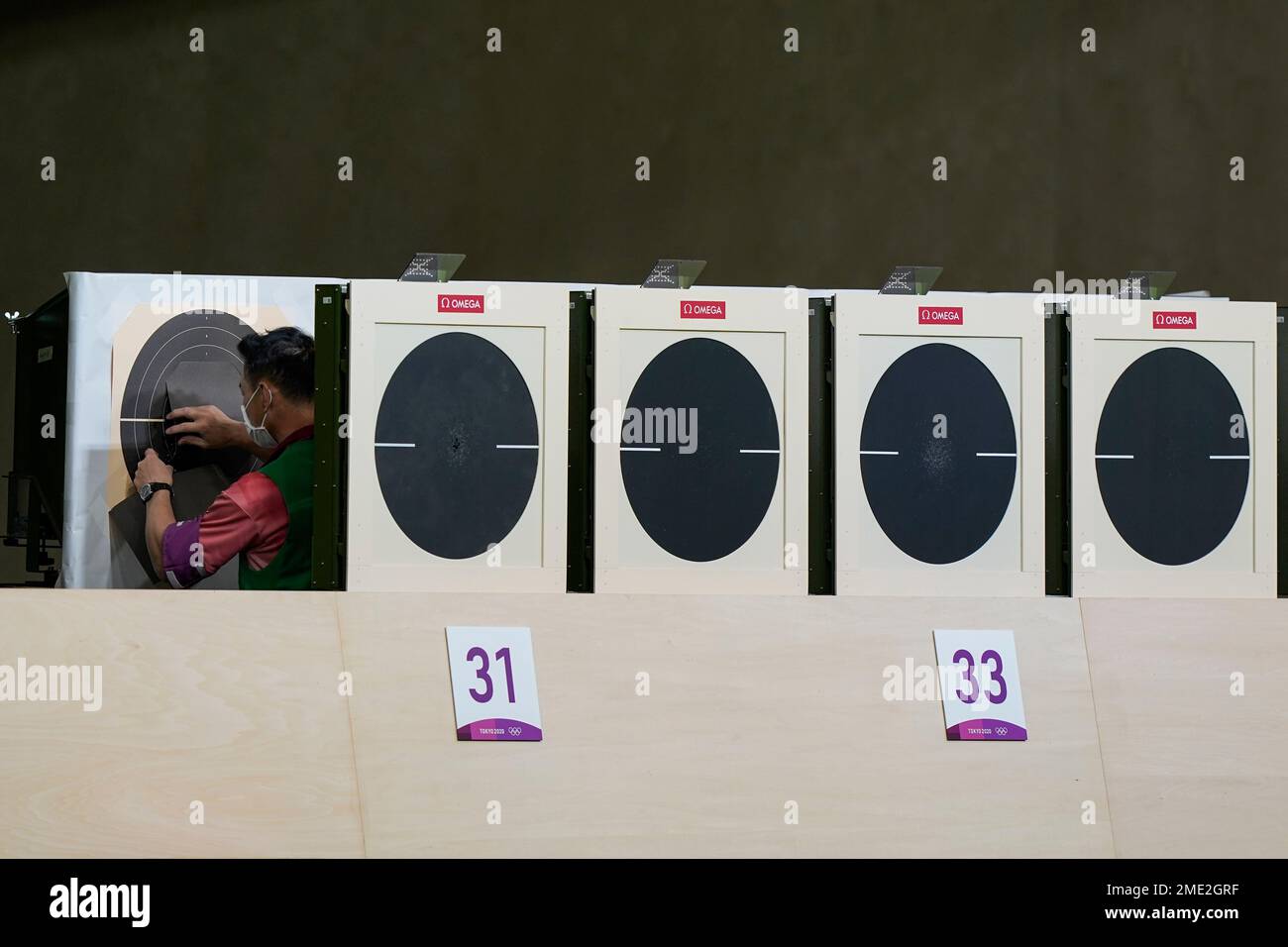 A range officer replaces the targets between groups of athletes for the ...