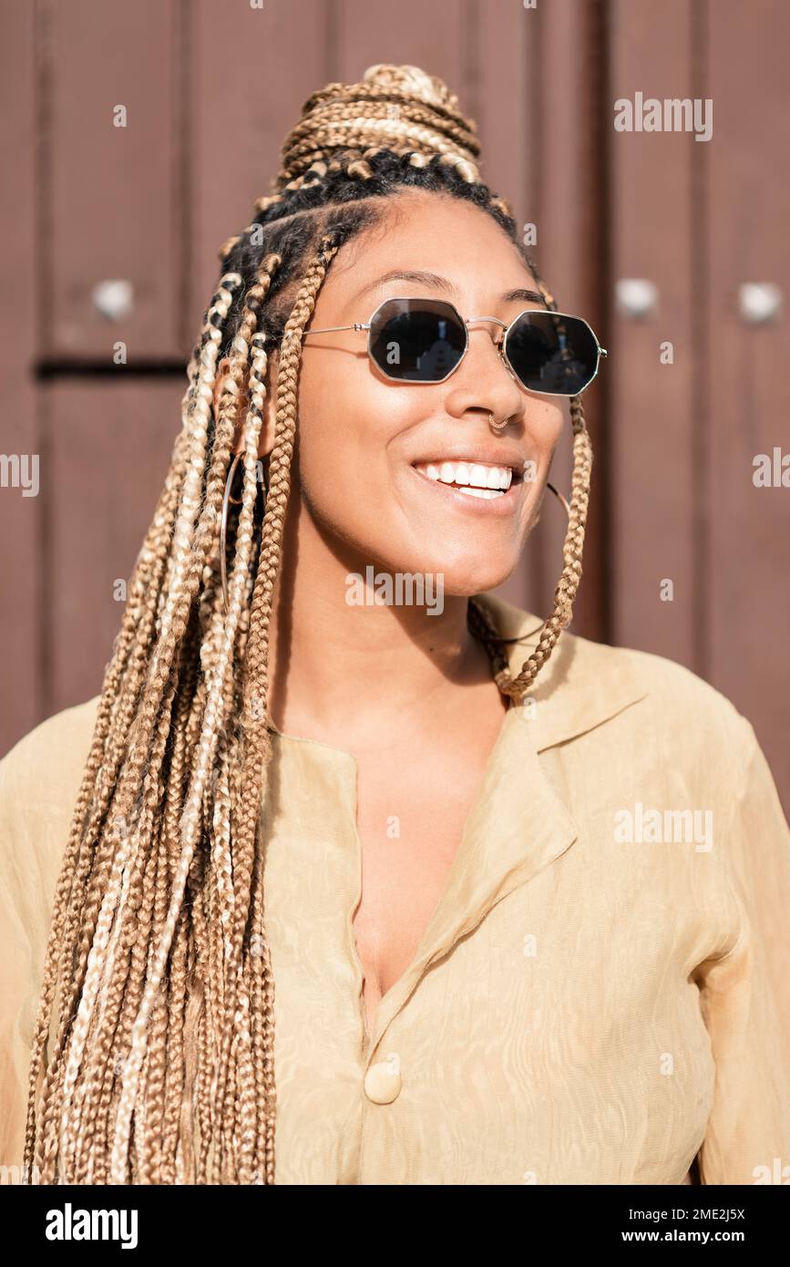 Portrait of cheerful young African American female with braids in ...