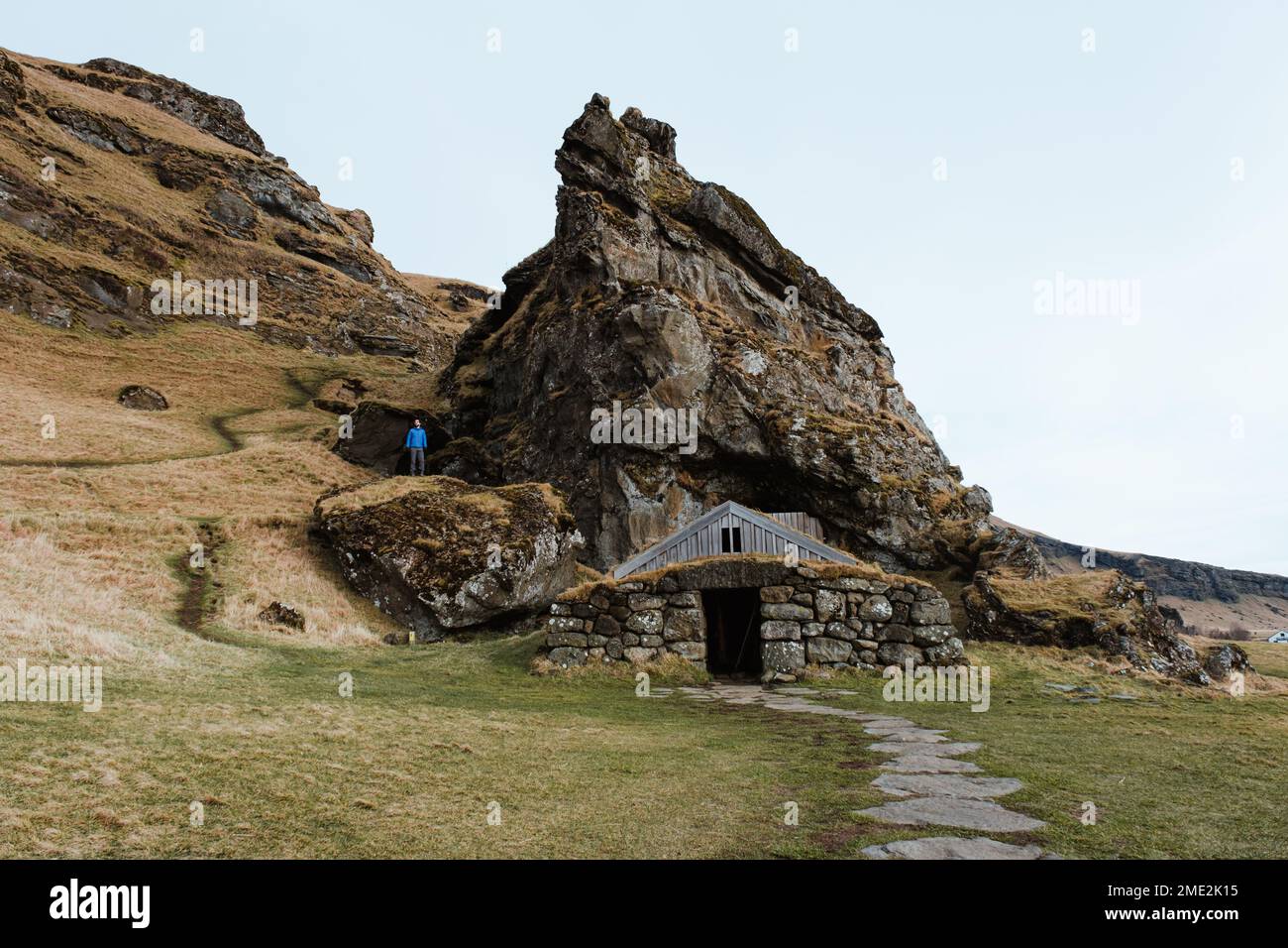 Traveler standing on boulder near aged house located at entrance of ...