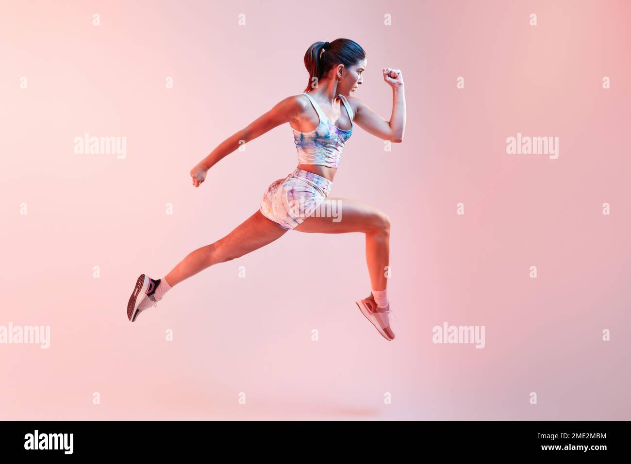 Full body side view of fit young female in colorful top and shorts ...