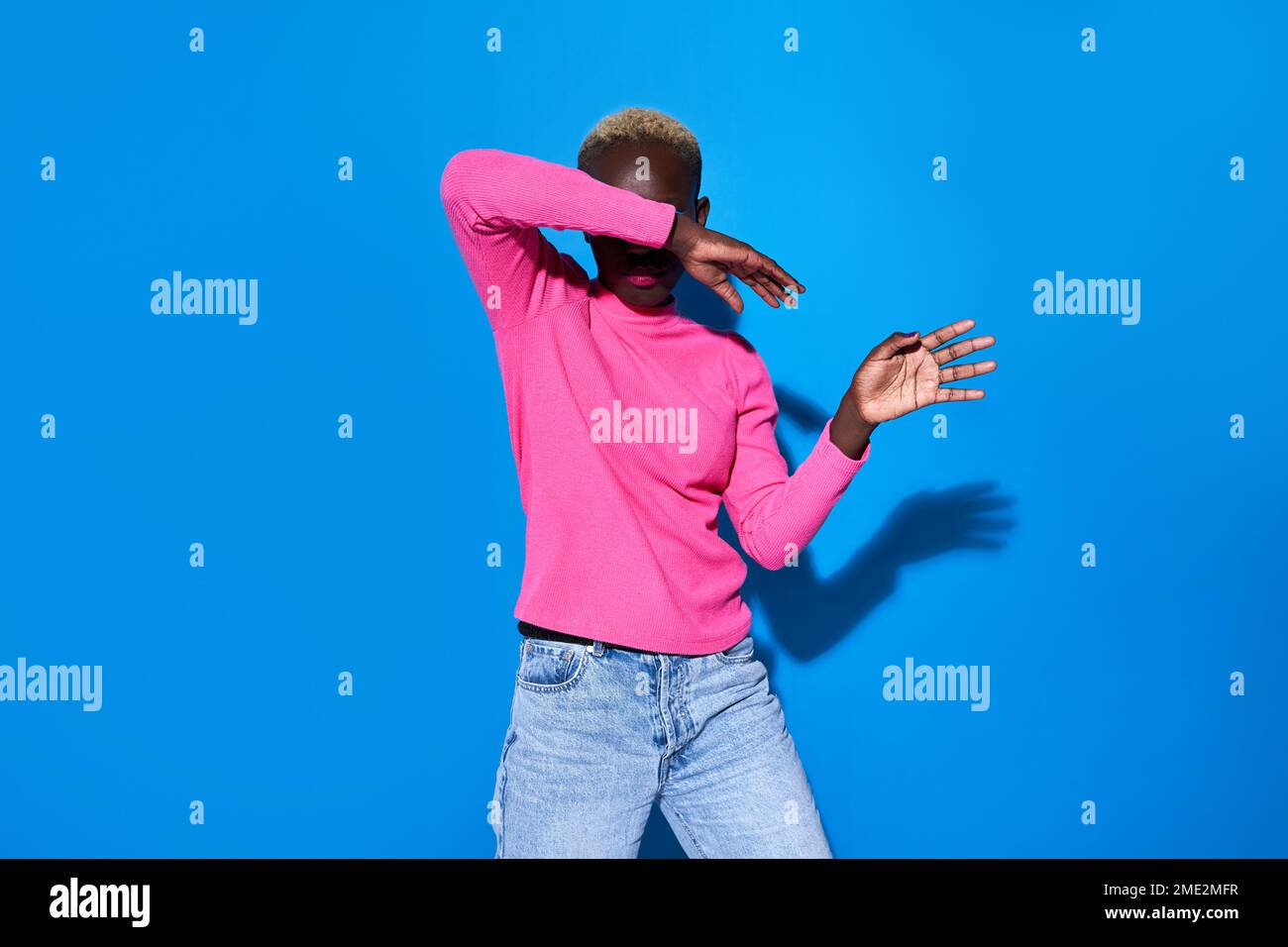 Anonymous African American female model in pink turtleneck and jeans ...