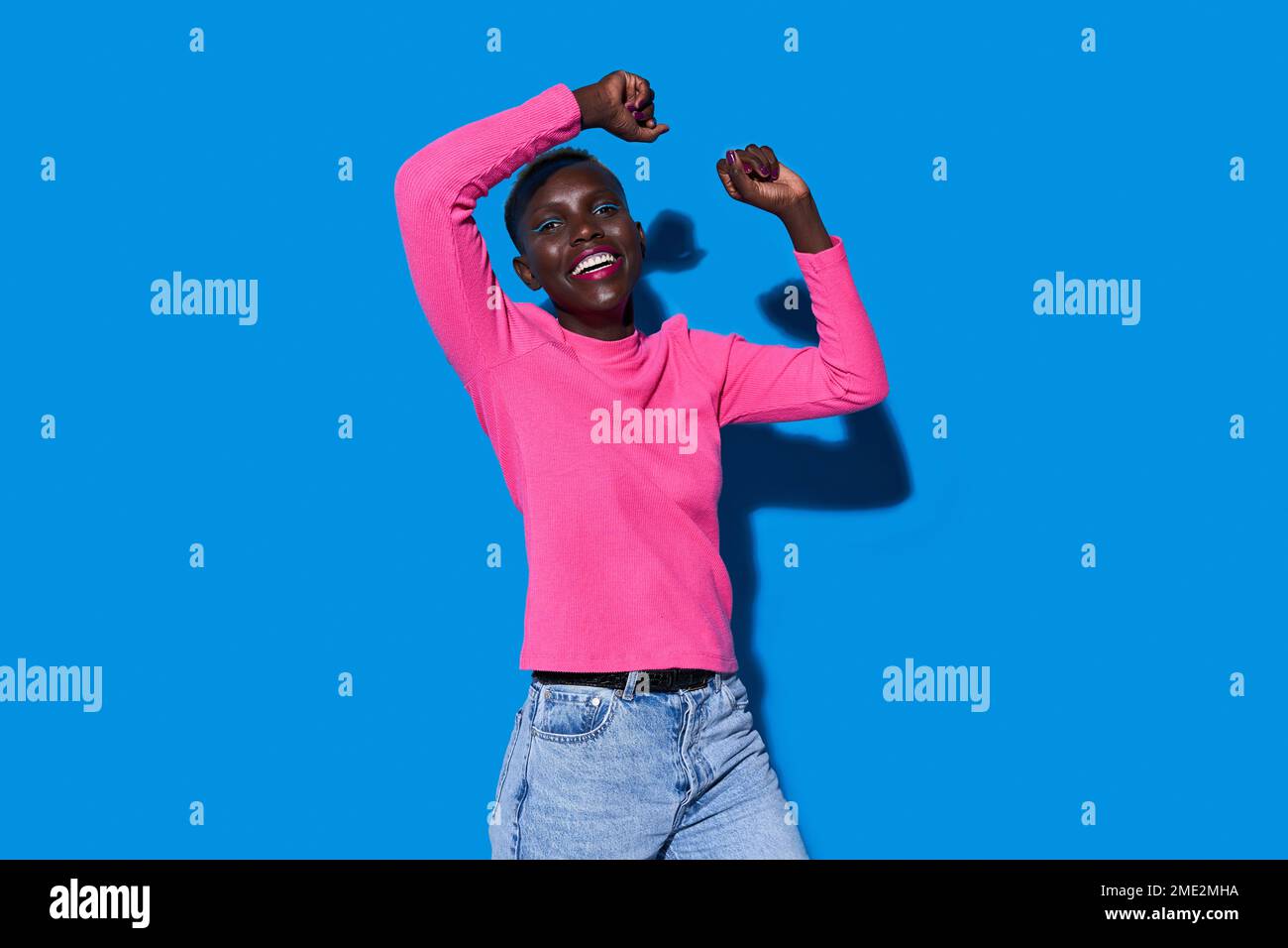Happy African American female in pink turtleneck and with bright ...