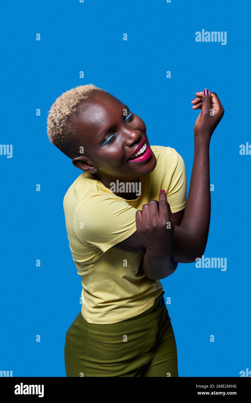 Happy African American female with bright colorful makeup smiling while ...
