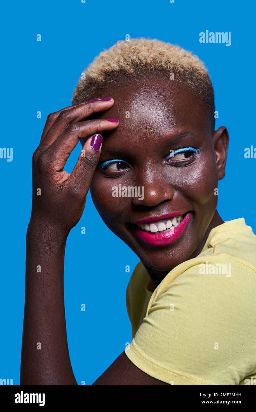 Positive African American female with short hair and makeup touching ...