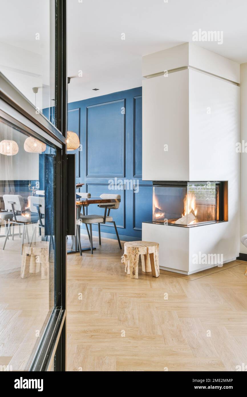 Opened glass door leading to modern dining room with glass fireplace in ...
