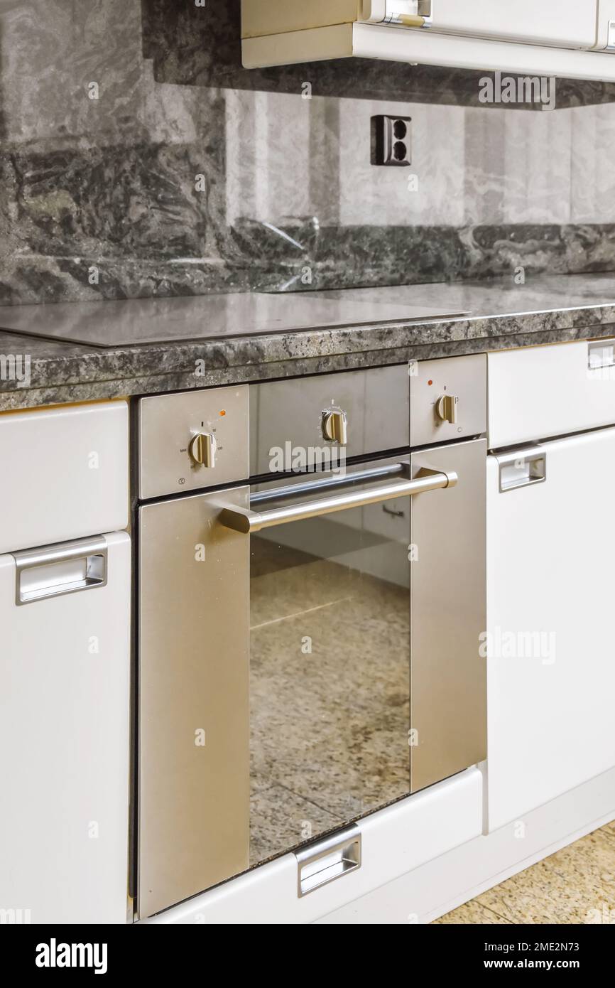 Interior of contemporary kitchen with built in oven and stove and ...