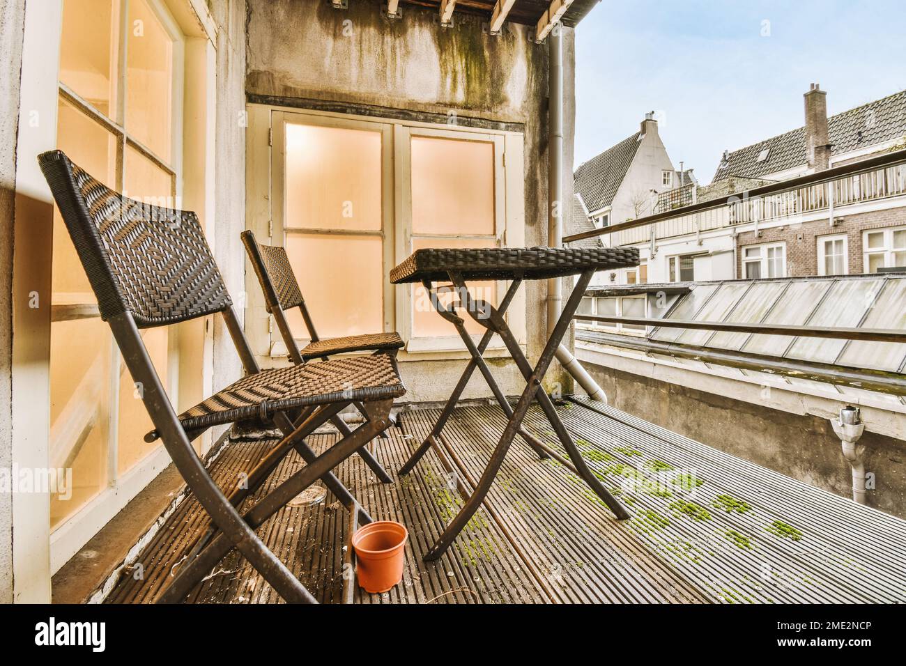 Old shabby multistory residential building with garden table and chairs ...