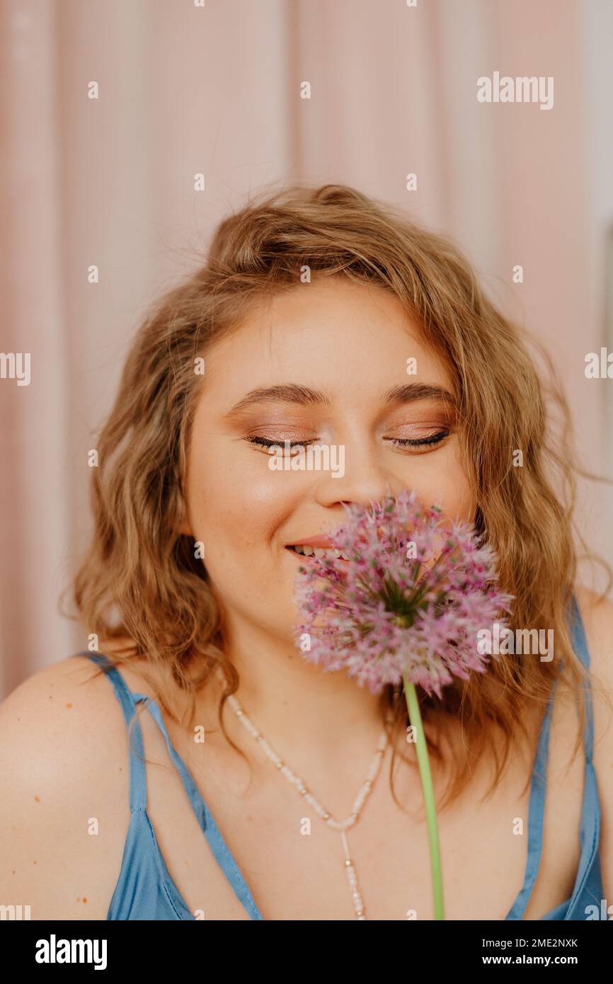 Romantic lady in silk strap dress sitting on floor in studio and ...