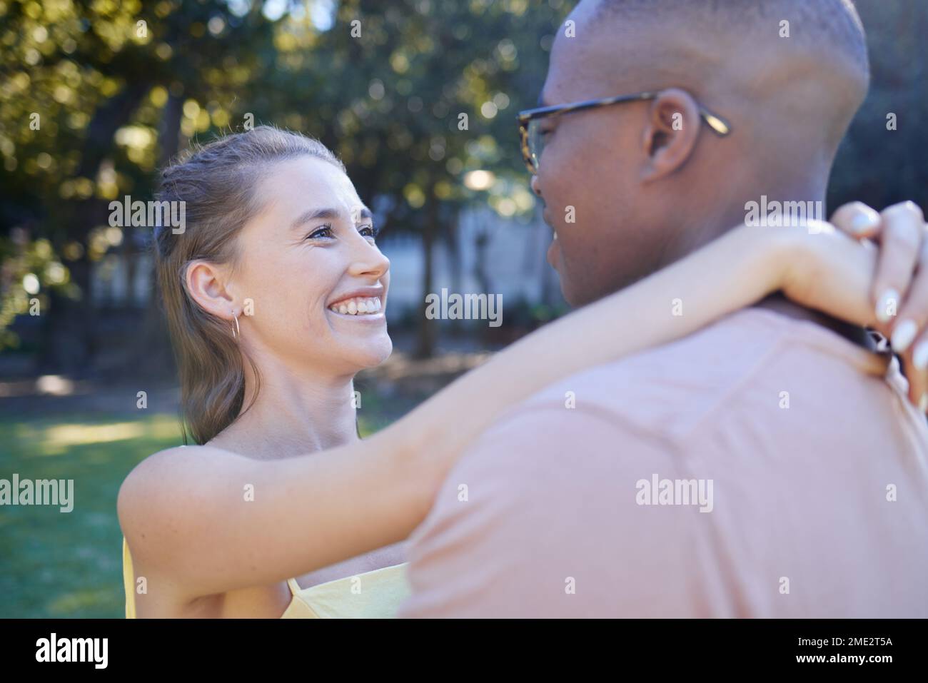 Interracial couple, smile and hug for romantic love, care or embracing ...