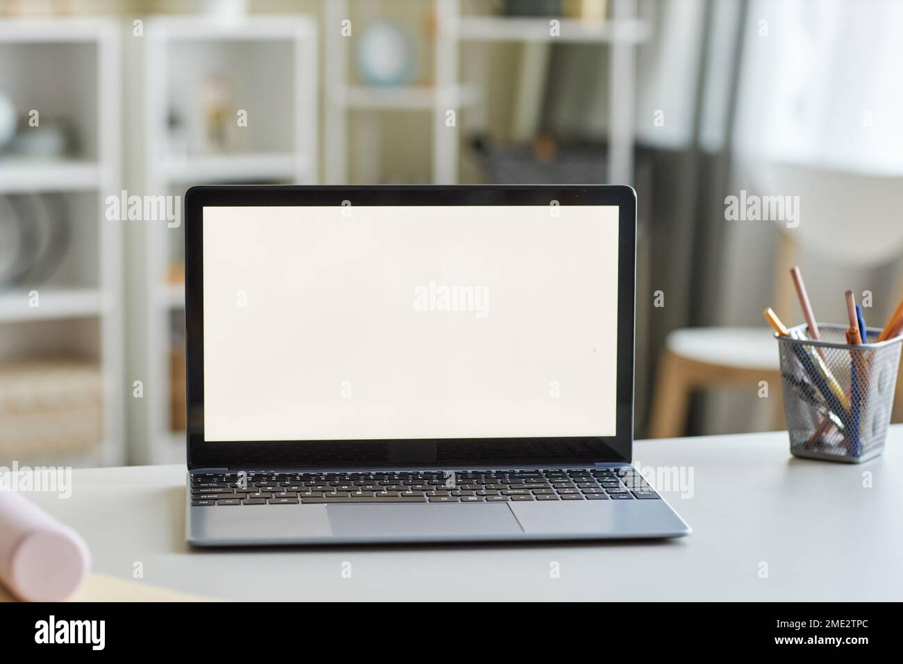 Close up of open laptop with blank white screen mockup on students desk ...