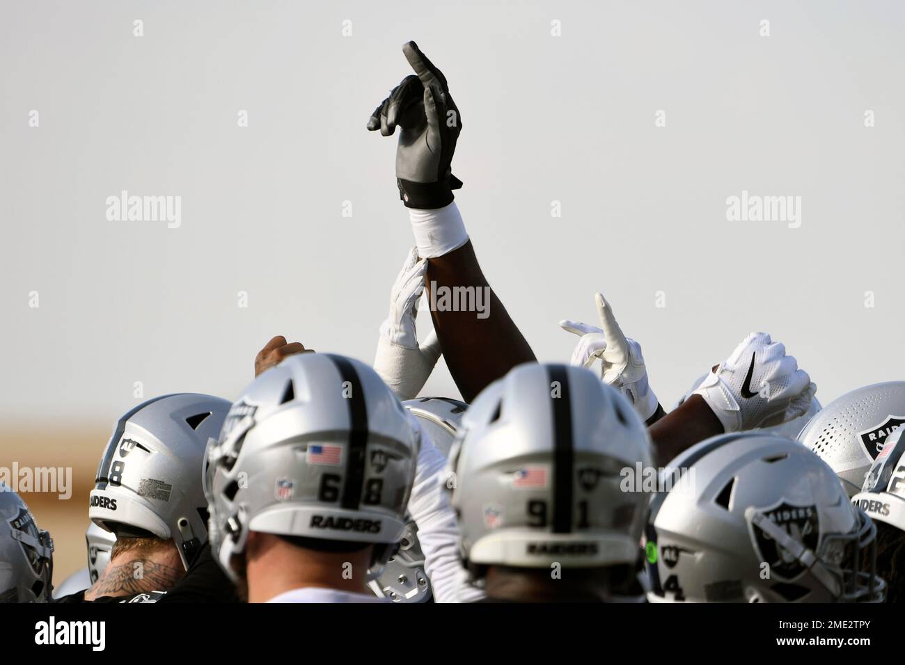 A hand is raised as the Las Vegas Raiders huddle during an NFL football ...