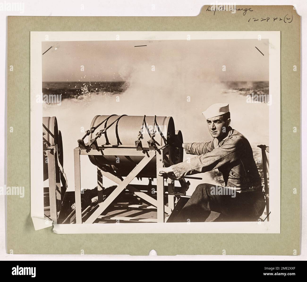 A Coast Guardsman stands ready to release a depth charge from a U.S ...