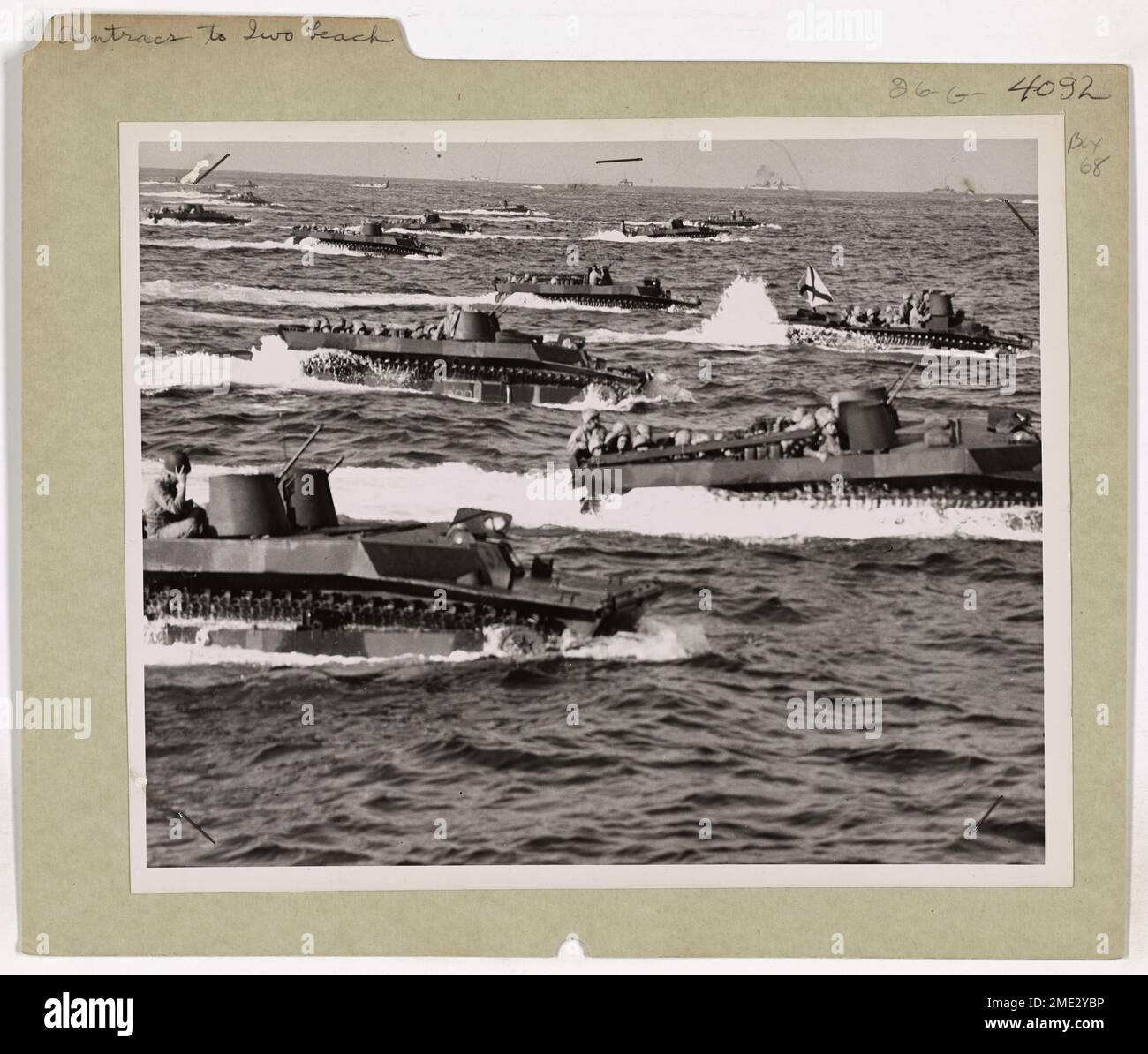 Amphibious vehicles, known as Amtracs, advance through the waters off ...