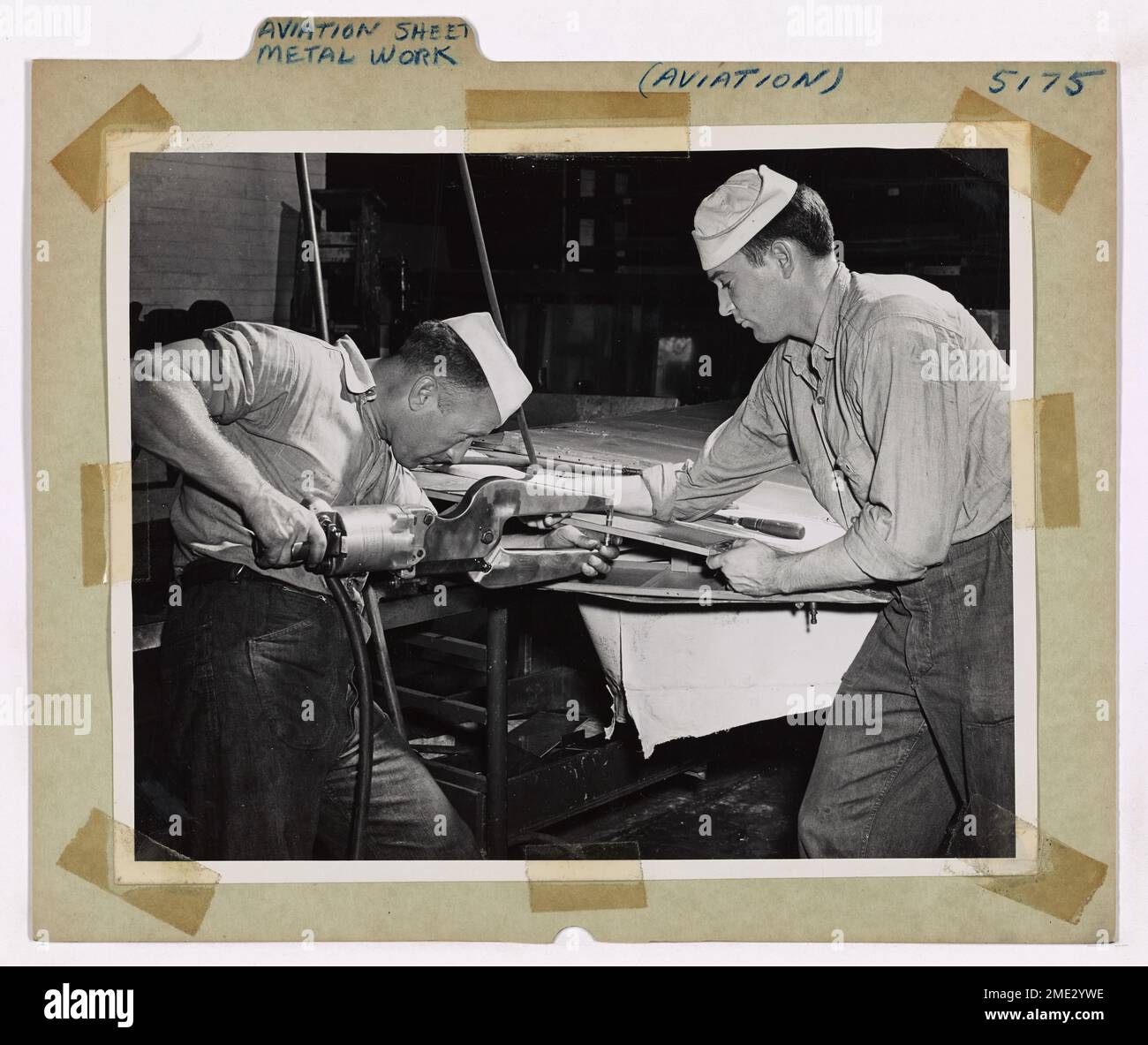 A Coast Guard aviation sheet-metal worker performs repairs on a ...
