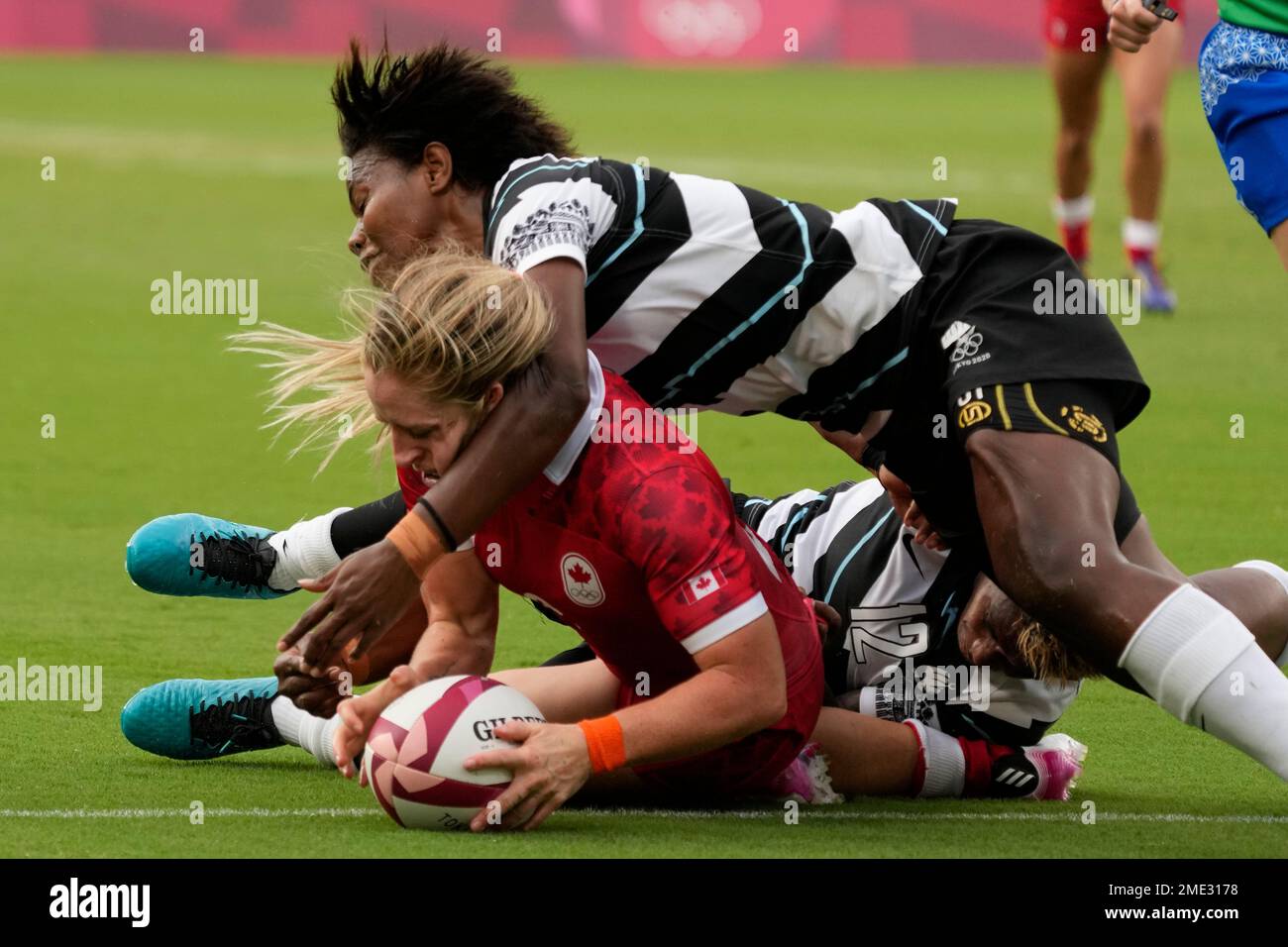 Fiji's Raijieli Daveua, top, lunges to tackle Canada's Kayla Moleschi ...