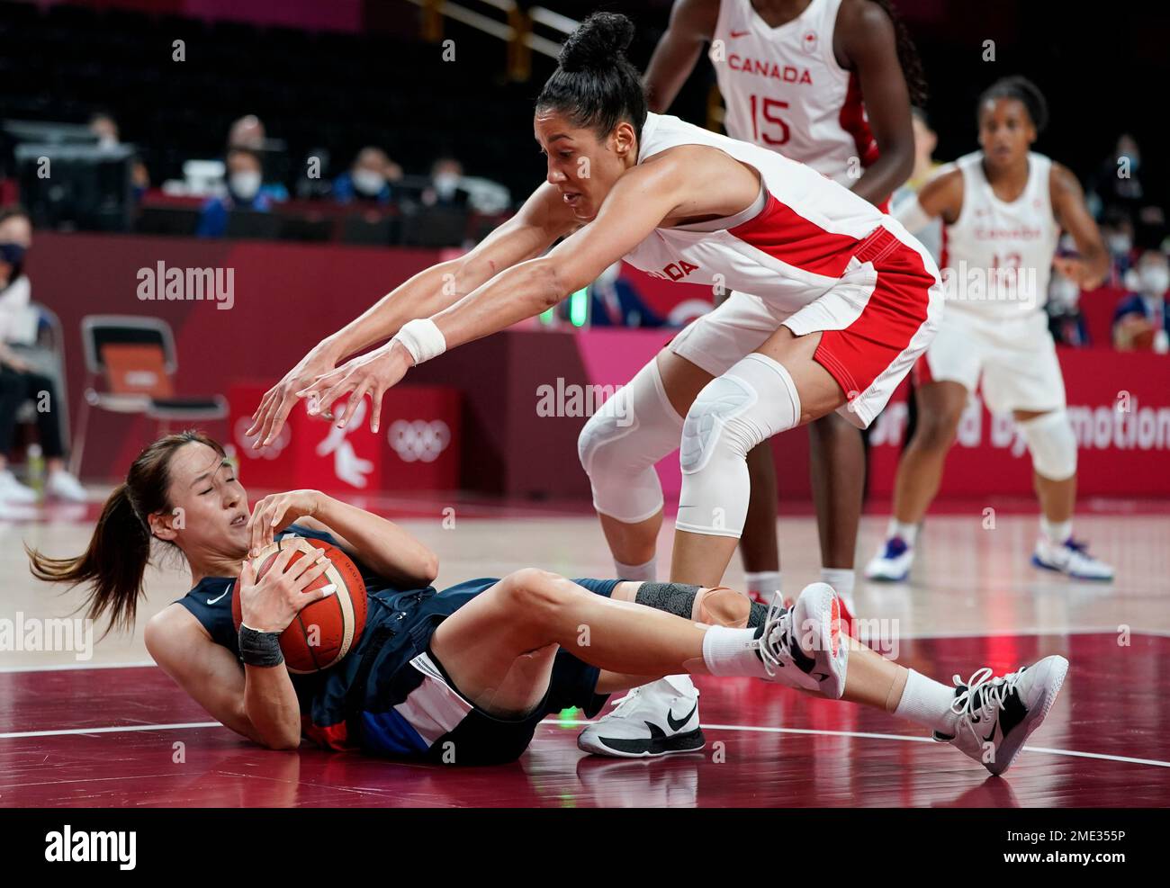 Canada's Miranda Ayim (9), top, and South Korea's Danbi Kim (23), on court, fight for the loose ...