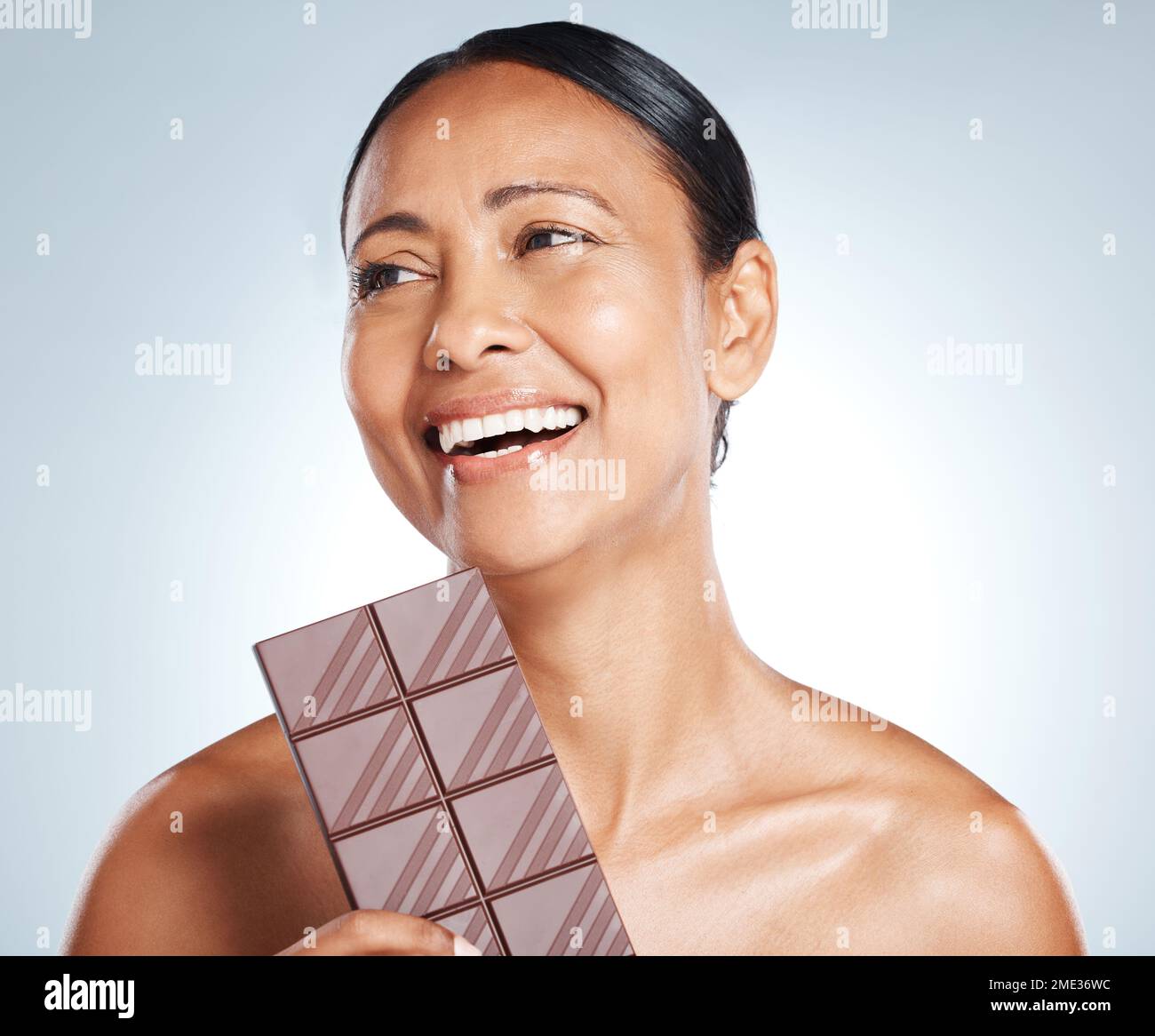 Chocolate, smile and senior woman thinking of health isolated on a blue ...