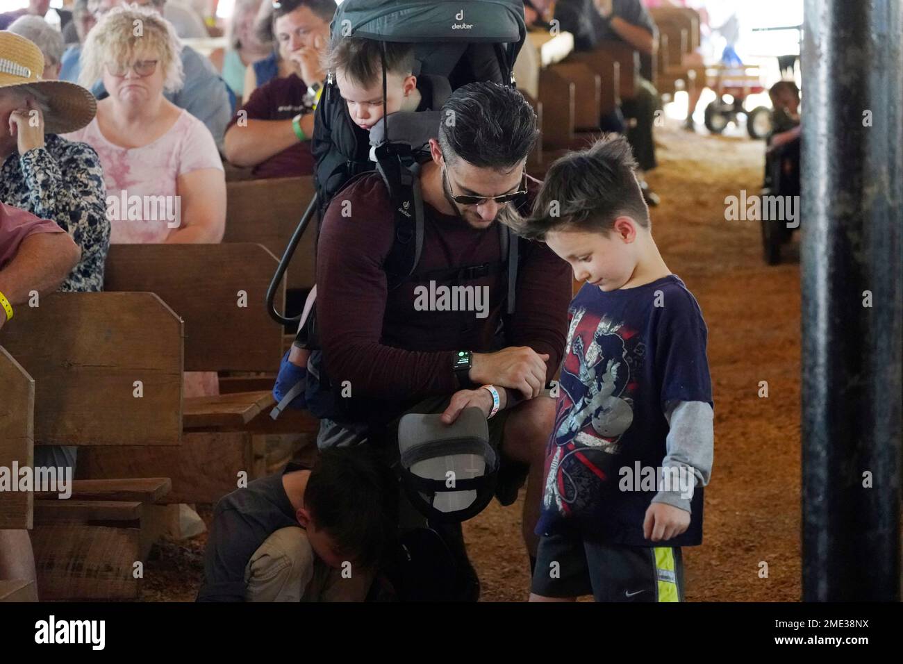 Samuel Shipley I kneels with his sons, Luke, 2, in the carrier, Noah, 4 ...