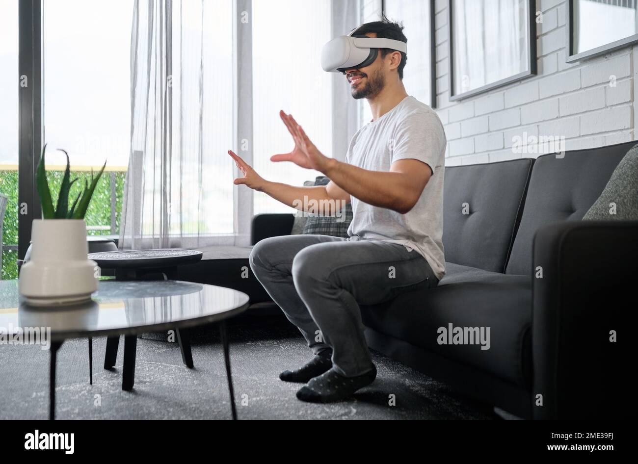 Virtual reality, futuristic technology and man on sofa with headset for ...