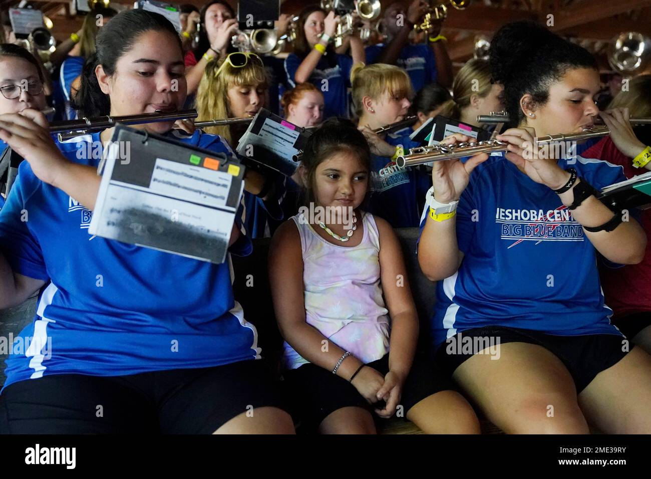 Sadie Ramirez, 7, center, has a reluctant smile as she sits through an ...