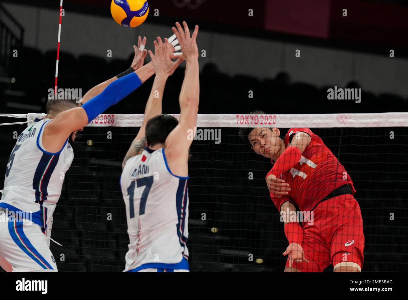 Japan's Yuji Nishida spikes a ball against Italy's Osmany Juantorena ...