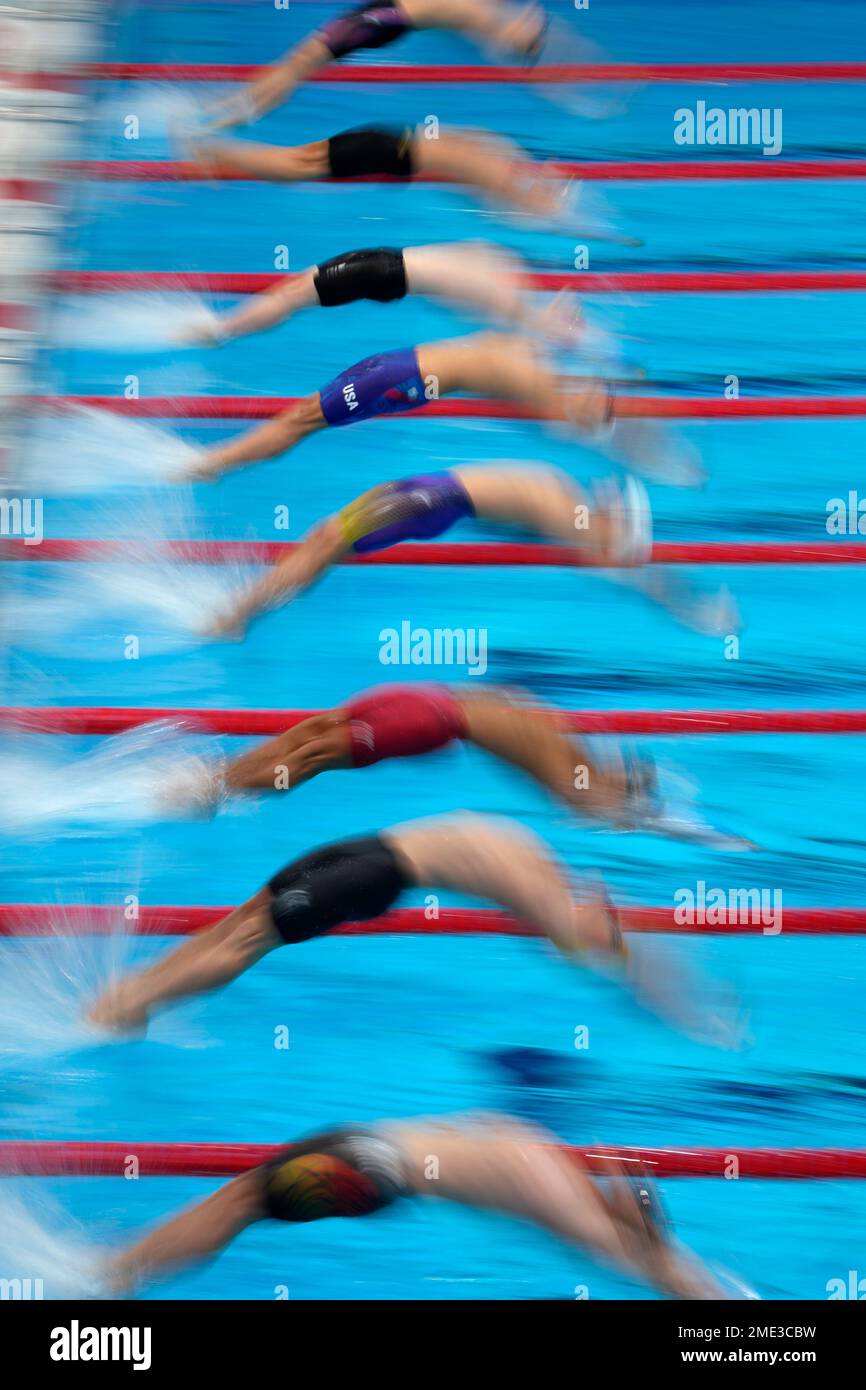 Swimmer dive in for the fourth heat of the men's 200-meter backstroke ...