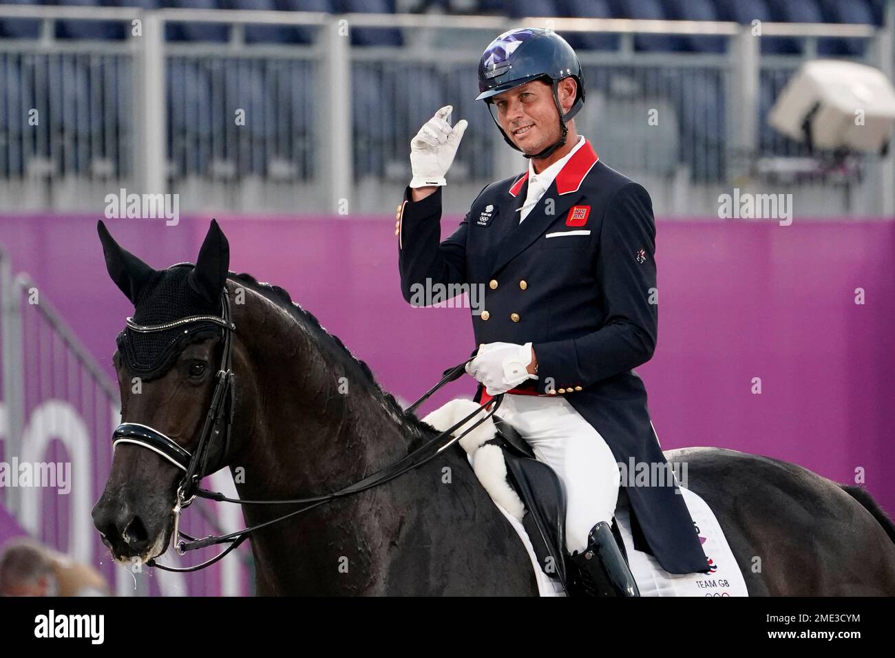 Britain's Carl Hester, riding En Vogue, tips his hat after competing in ...