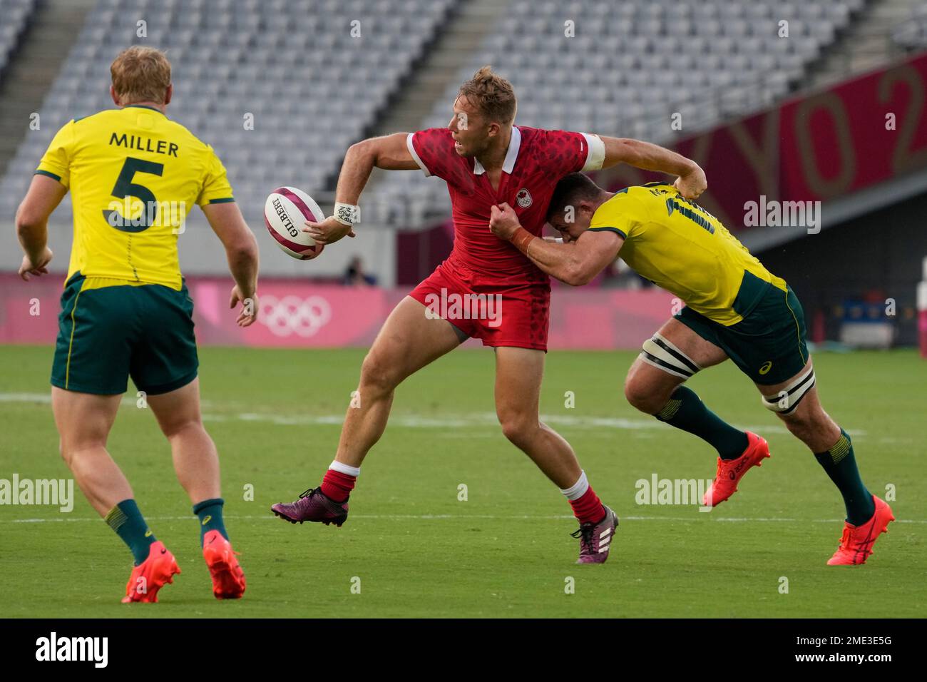 Canada's Harry Jones, center, passes under pressure from Australia's ...