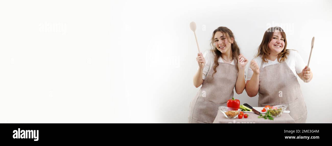 2 women dancing while preparing tasty and healthy food vegetarian food ...