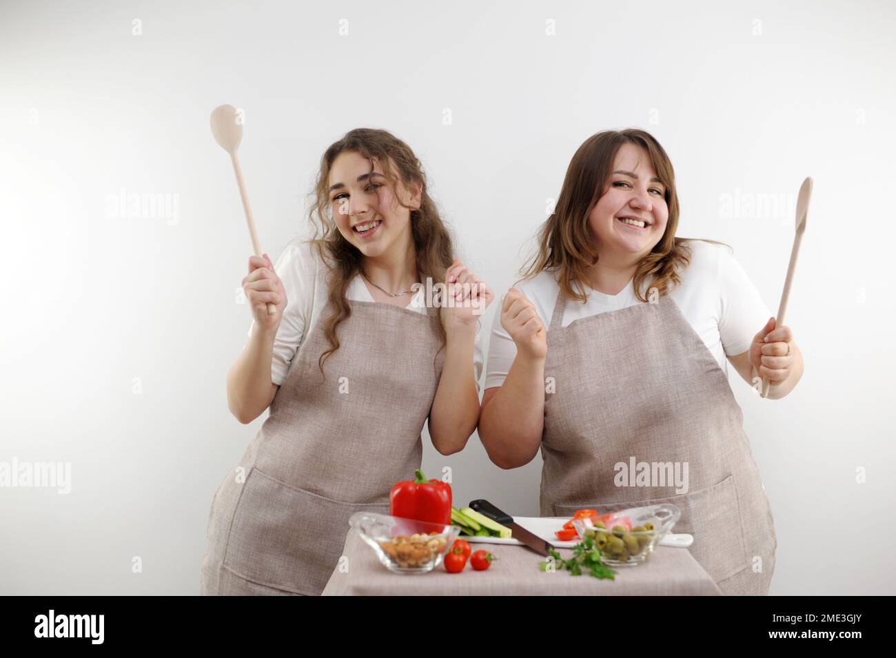 2 women dancing while preparing tasty and healthy food vegetarian food ...