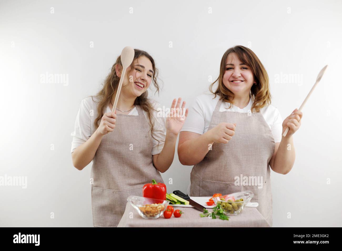 2 women dancing while preparing tasty and healthy food vegetarian food ...