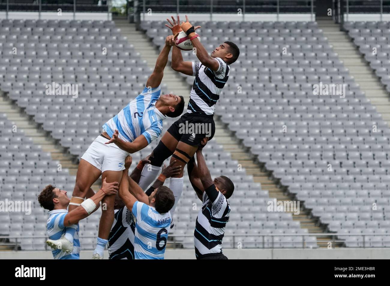 Argentina's Lucio Cinti, left, and Fiji's Meli Derenalagi are lifted by ...