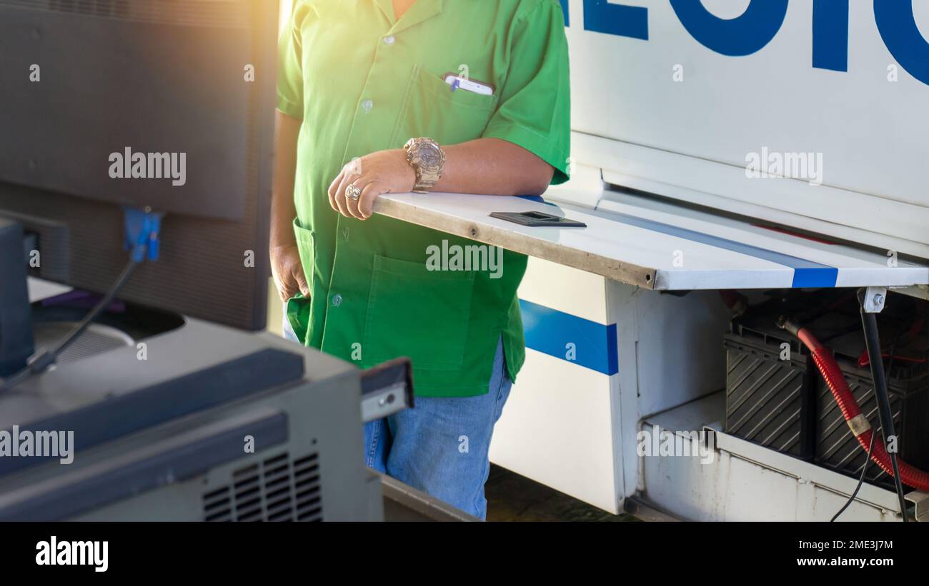 Latino bus mechanic checking the battery Stock Photo - Alamy