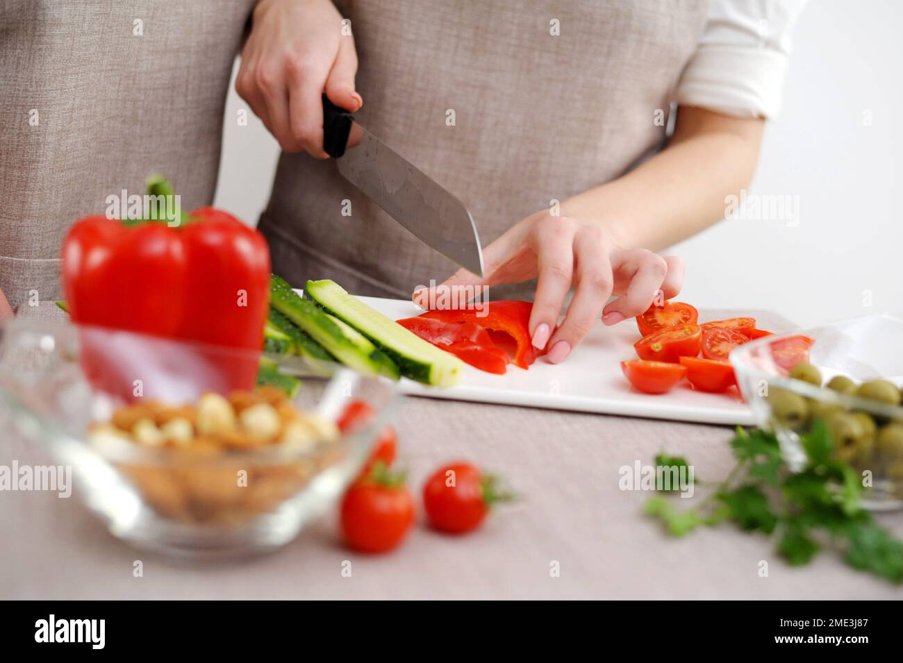Close up cropped image of cutting board and couple cutting vegetables ...