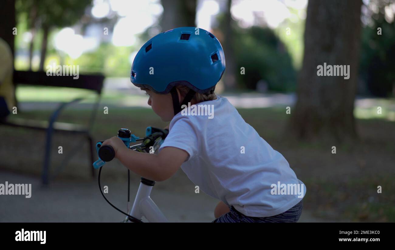 Active child learning to ride bicycle outside at park Stock Photo - Alamy