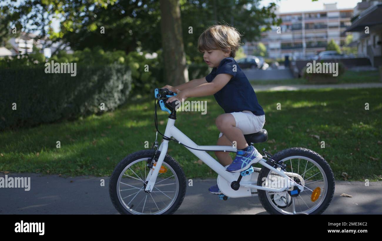 Active small boy riding bicycle outside child rides bike Stock Photo ...
