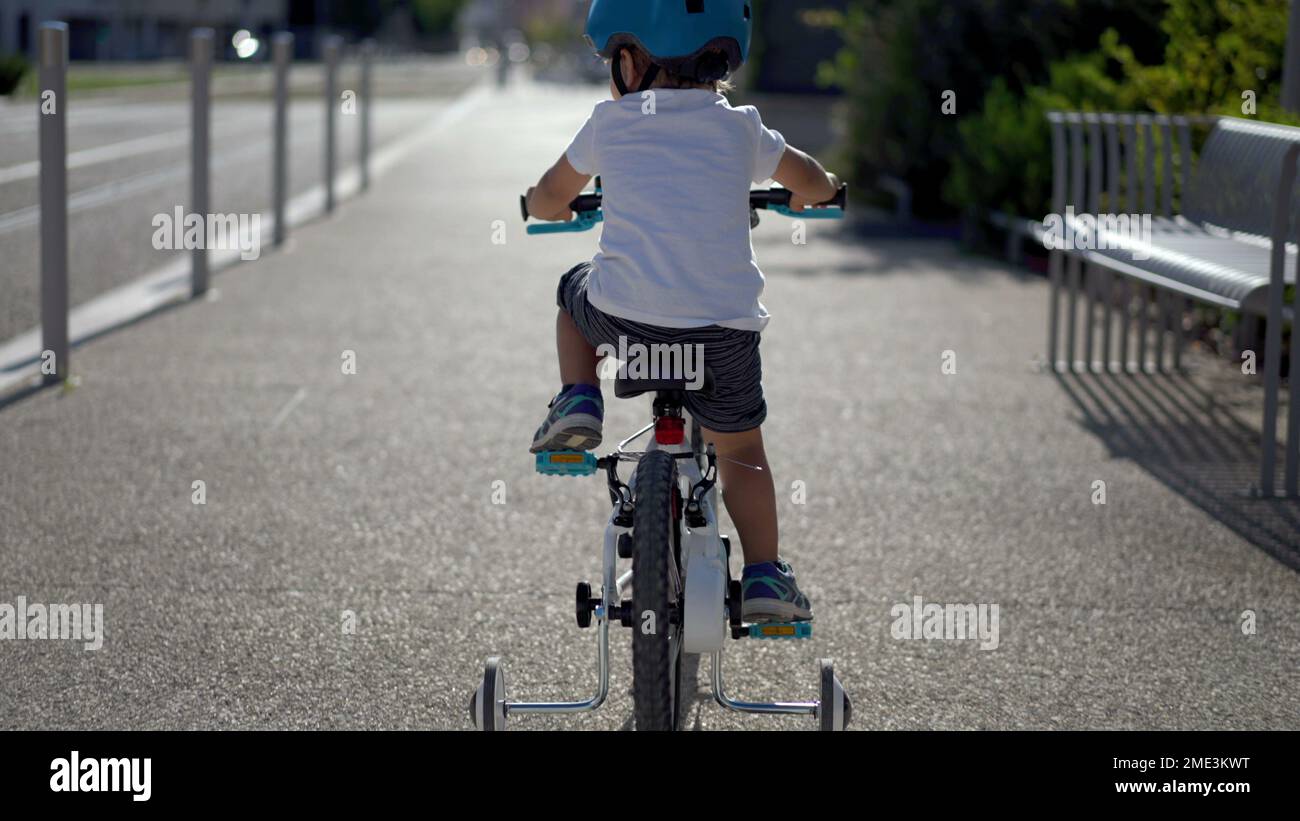 Back of little boy riding bicycle outside Stock Photo - Alamy