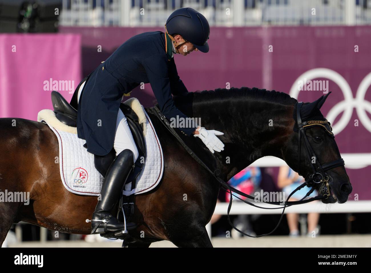 Portugal's Maria Caetano, pats her horse, Fenix de Tineo, after ...