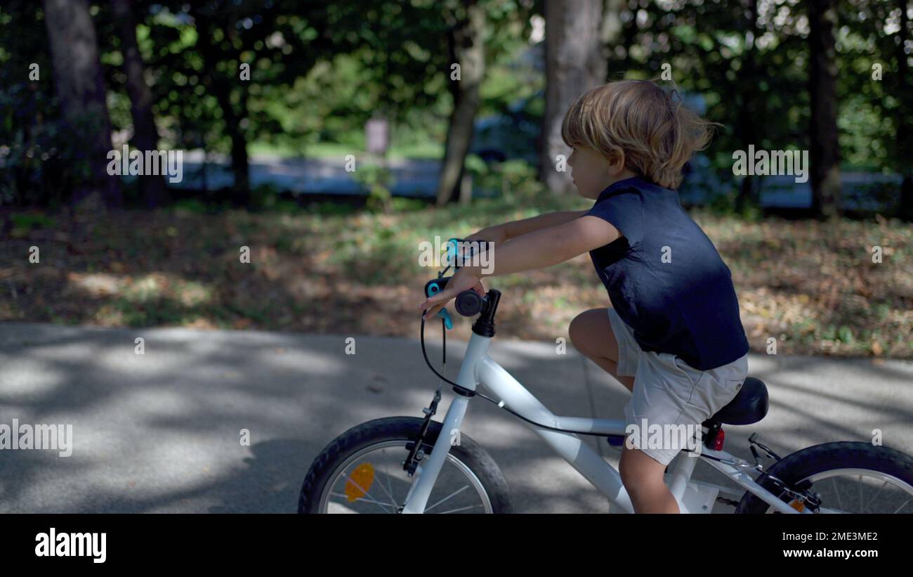 Little boy riding bicycle outside in the sunlight Stock Photo - Alamy