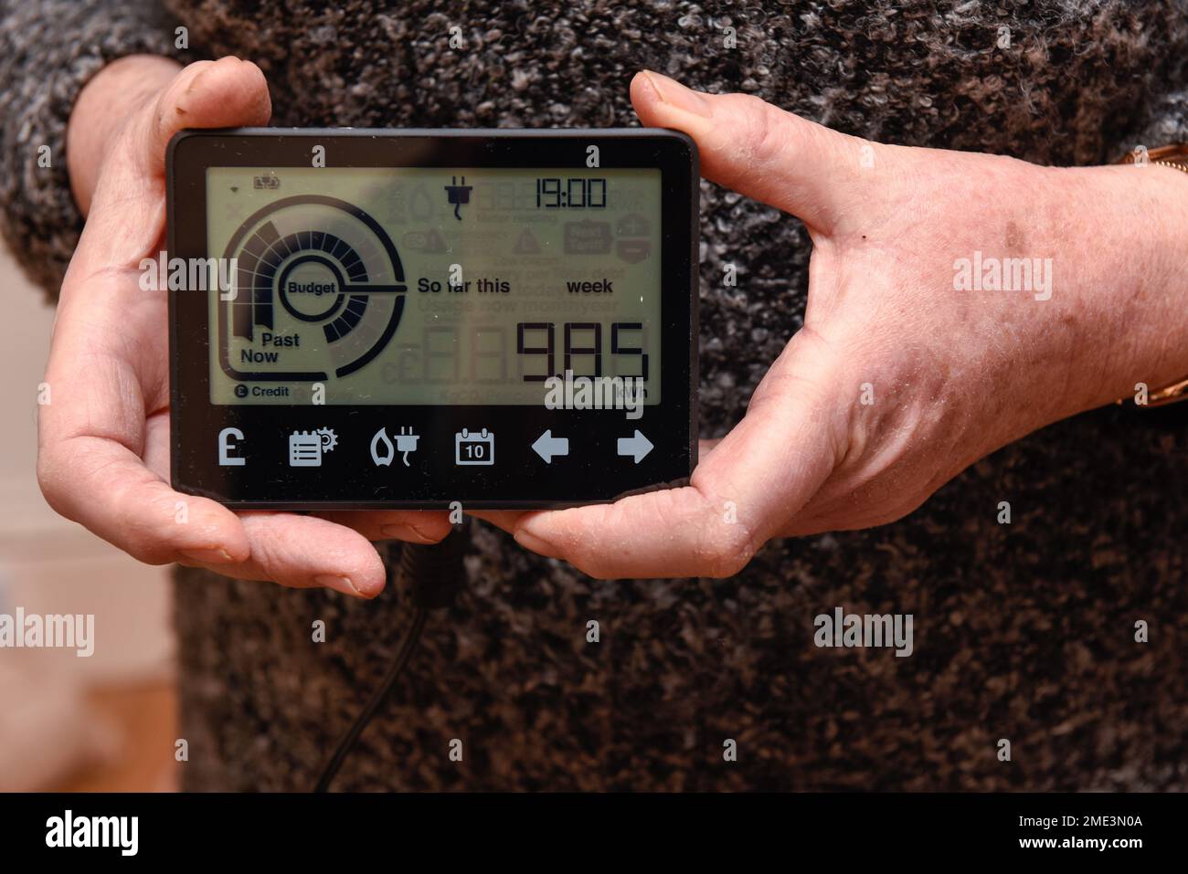A senior woman looks at the smart meter to budget for energy bills for ...
