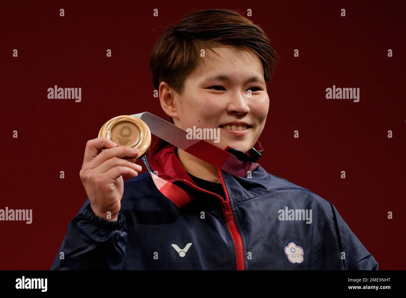 Chen Wen-Huei of Taiwan holds the bronze medal on the podium of the women's 64kg weightlifting ...