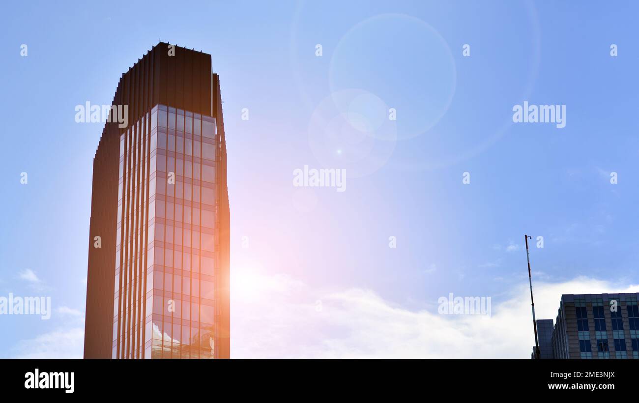 Modern glass facade against blue sky. Bottom view of a building in the ...
