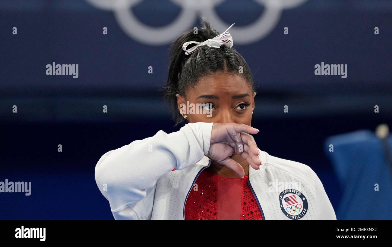 Simone Biles, of the United States, watches gymnasts perform after she ...