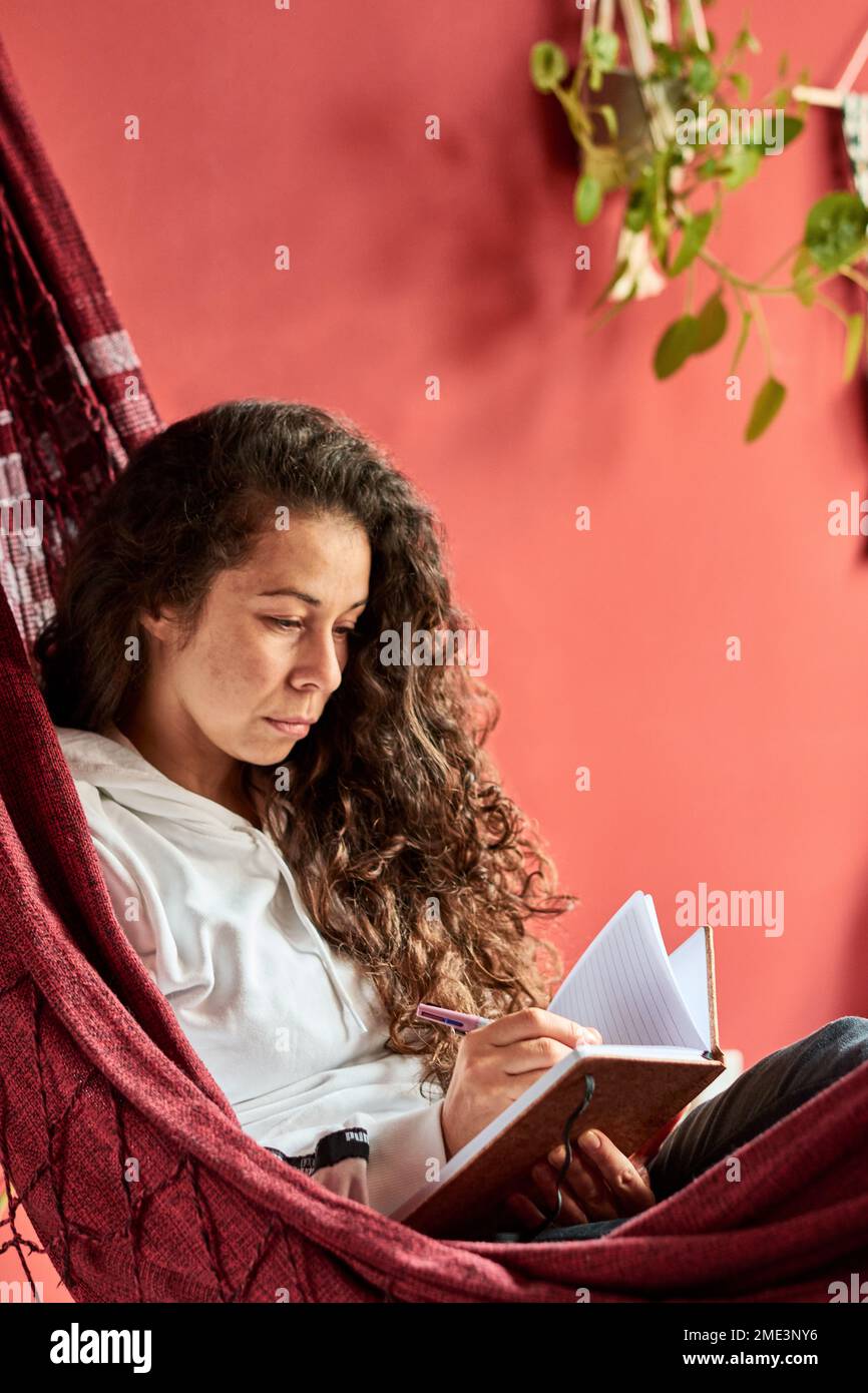 Woman writing in a hammock Stock Photo - Alamy